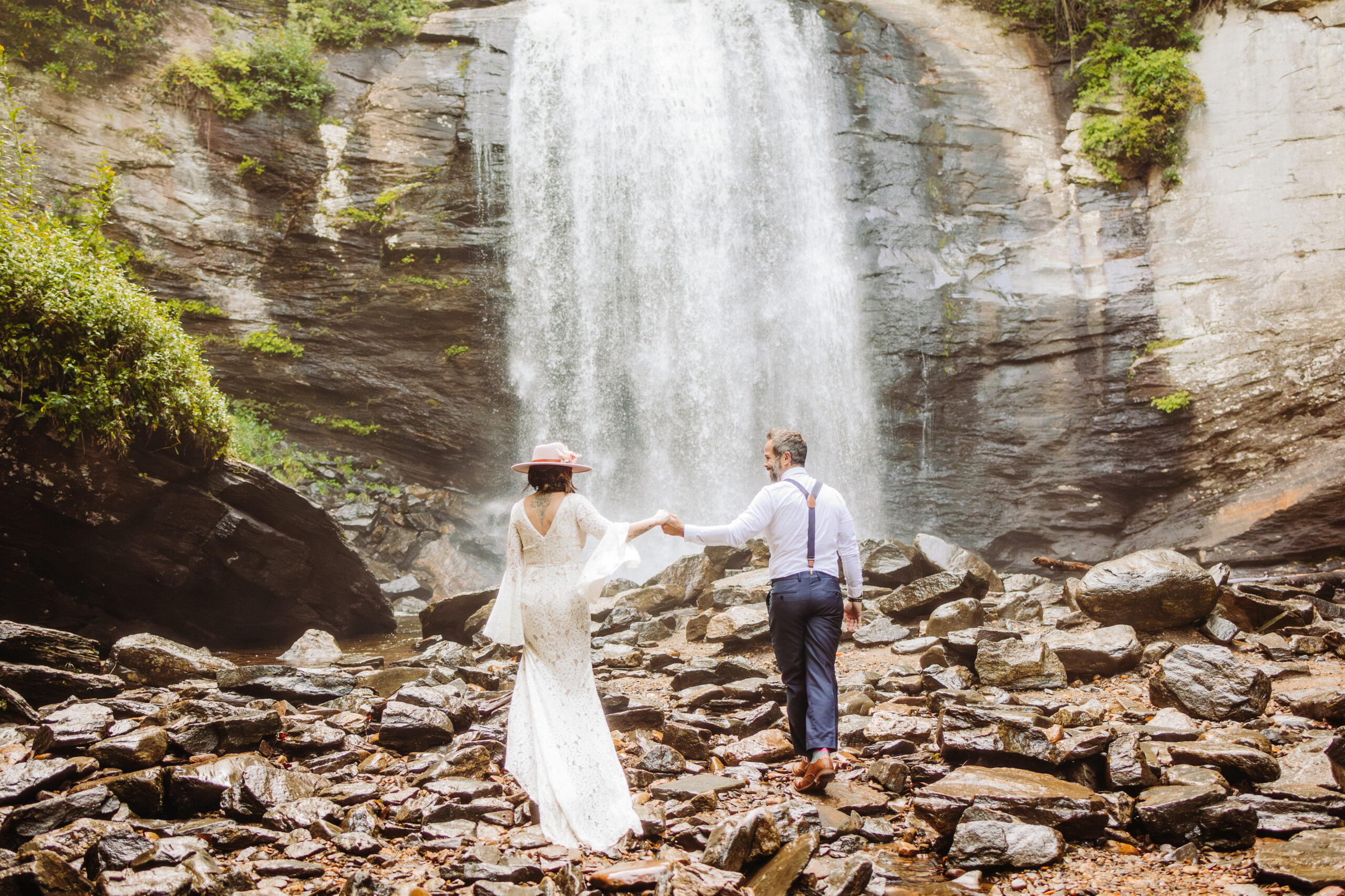 couple walks to waterfall elopement ~ Elope Outdoors